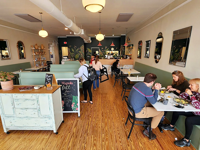 Sage green wainscoting meets vintage-inspired mirrors in this thoughtfully designed space that feels like your stylish friend's dream breakfast nook.