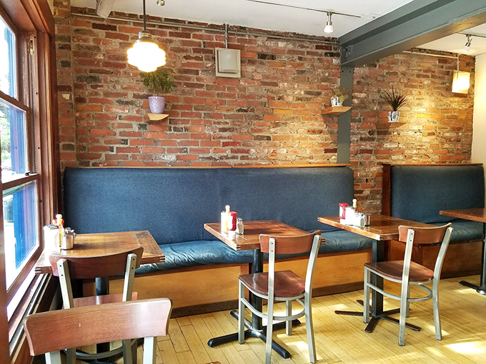 Exposed brick walls and cozy blue banquettes create the perfect backdrop for morning conversations and coffee revelations.