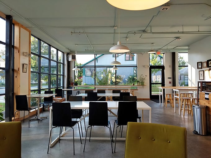 Sunlight streams through floor-to-ceiling windows, creating a bright, airy space where modern minimalism meets cozy Vermont charm.