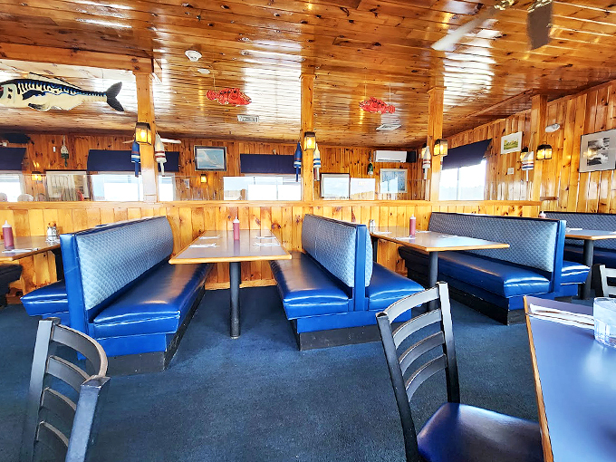 Knotty pine walls and navy blue booths create the perfect maritime mood, while wooden fish swim eternally overhead in this cozy dining room.