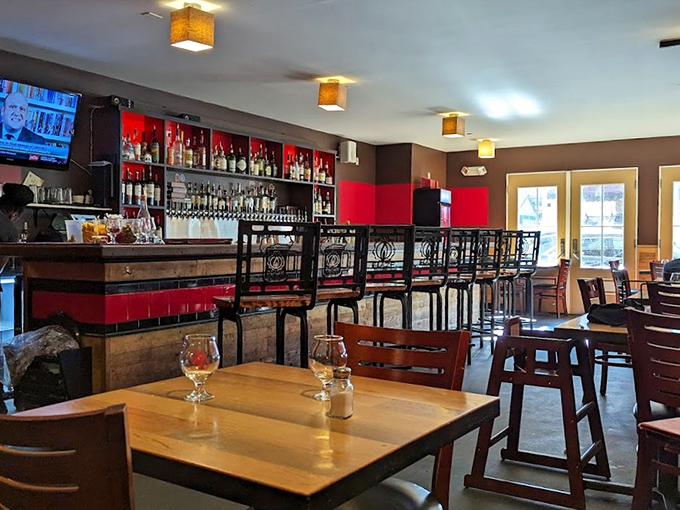 Warm wood tones and red accents create an inviting atmosphere, while natural light streams through windows overlooking Bar Harbor's streets.