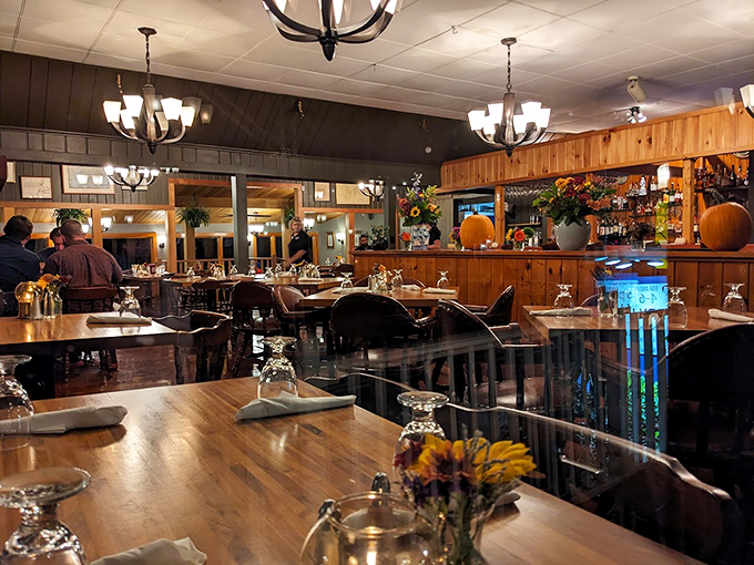 Warm wood paneling and nautical charm create the perfect backdrop for memorable meals, while chandeliers cast a golden glow over happy diners. Photo credit: Loves Traveling