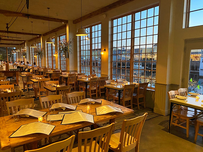 Floor-to-ceiling windows frame Portland's working waterfront, while wooden tables and warm lighting create the perfect maritime dining atmosphere. Photo credit: Moses Baik