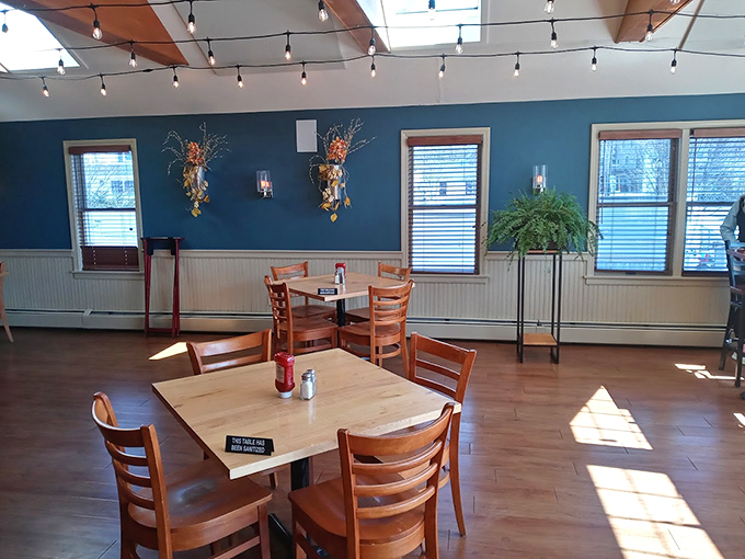 String lights dance overhead while sunlight streams through windows, creating the perfect coastal dining atmosphere that feels like home. Photo credit: Stayc
