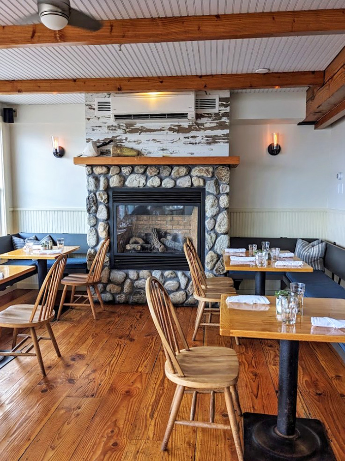 The stone fireplace and wooden beams create a cozy maritime haven where comfort meets coastal charm. Like a warm hug on a chilly evening.