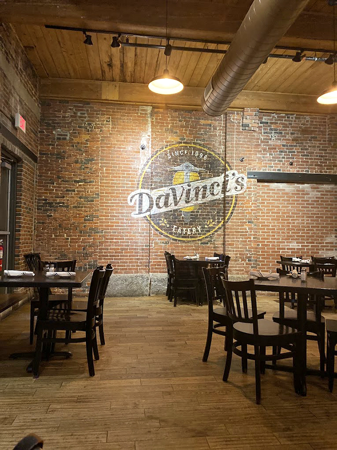 Exposed brick meets modern charm in this dining room, where the painted logo watches over happy diners like the Mona Lisa.
