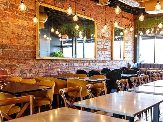 Edison bulbs cast a warm glow over exposed brick and velvet seating – it's industrial chic meets cozy comfort.