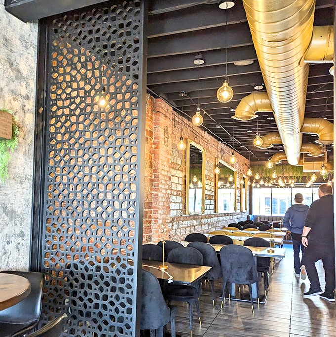 Industrial-chic meets Middle Eastern elegance with geometric screens, exposed brick walls, and warm Edison bulbs creating an inviting atmosphere.