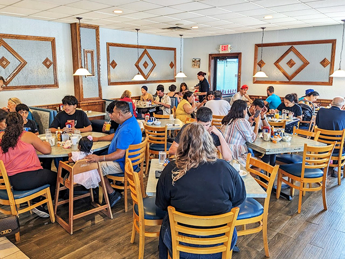 Diamond-patterned walls and wooden accents frame a bustling dining room where families gather for their morning ritual of coffee and conversation.