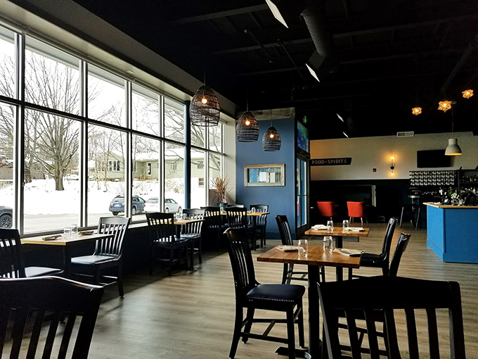Floor-to-ceiling windows flood the modern dining room with natural light, while woven pendant lamps add a touch of tropical charm. Photo credit: Jonell Bowman