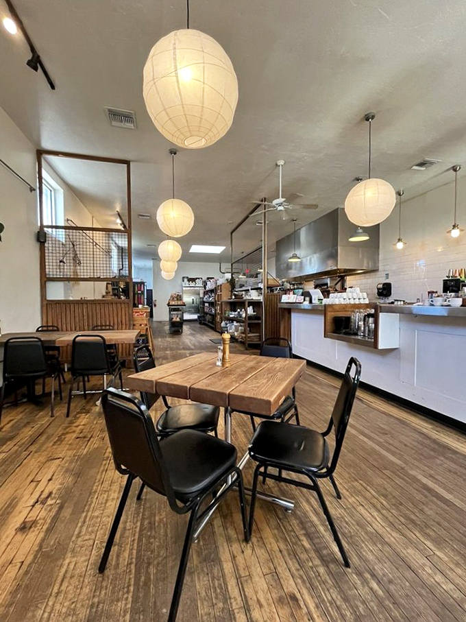 Paper lanterns cast a warm glow over rustic wooden tables, creating the perfect spot for morning conversations.