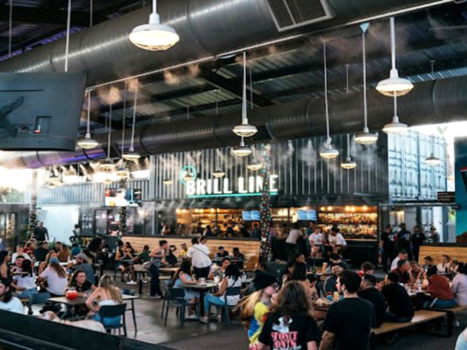 Under industrial chic lighting, The Churchill buzzes with energy as diners gather at communal tables for food, drinks, and conversation. 