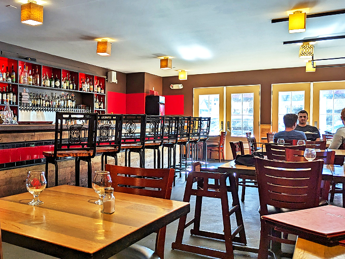 The warm wood tones and red accents create an atmosphere that's part cozy pub, part upscale bistro &ndash; like your sophisticated friend's living room, but with better drinks. Photo credit: Ken Kreterfield