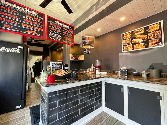 The cozy interior features sleek black menu boards and marble countertops, creating a modern twist on classic sandwich shop charm.