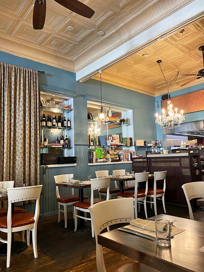 Crystal chandeliers meet cozy blue walls in this elegant dining room. It's like your fancy aunt's parlor, but with better drinks.