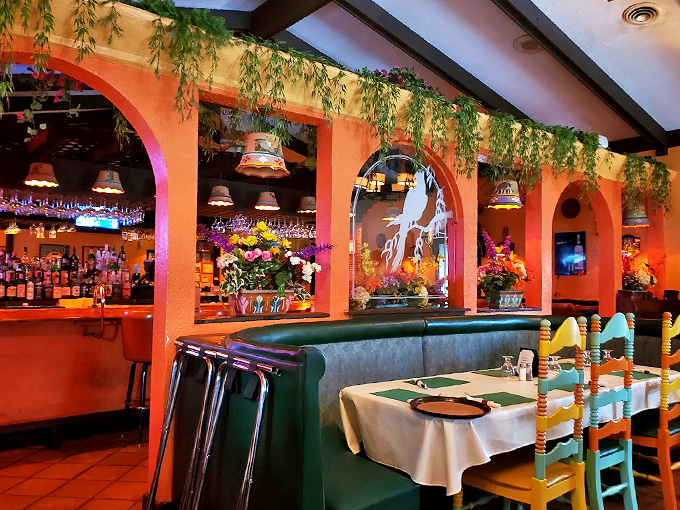 Terracotta arches frame the bar like a Renaissance painting, while hanging plants create an atmosphere that's pure Mexican magic.