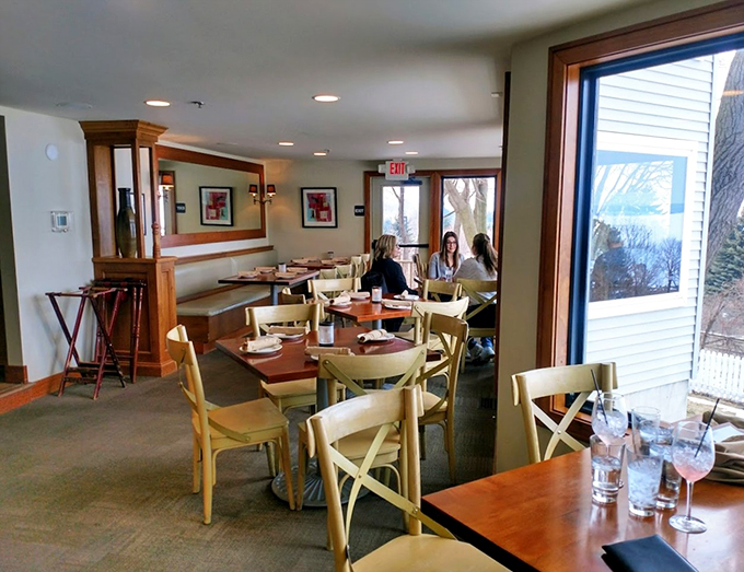 Cream-colored bistro chairs and warm wood accents frame stunning bay views, creating the perfect setting for memorable meals.