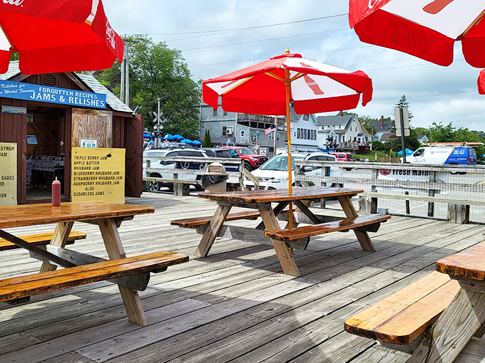 Picnic tables under red umbrellas offer the perfect spot to enjoy your feast while soaking in those refreshing ocean breezes.