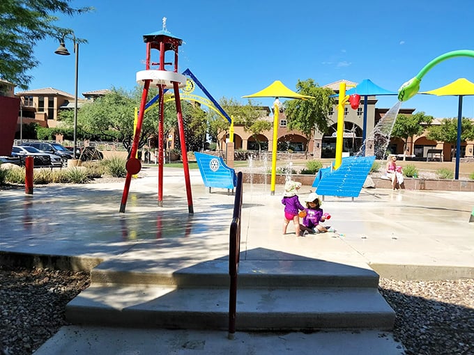 A colorful splash pad paradise where kids can cool off while parents relax under the desert sun's warm embrace.