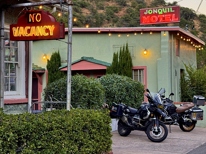 As dusk settles, the neon signs cast their warm glow like a beacon for weary travelers and poetry enthusiasts alike.
