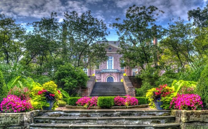 Downton Abbey's gardener went rogue! Manicured terraces and tulip seas frame a stately mansion.