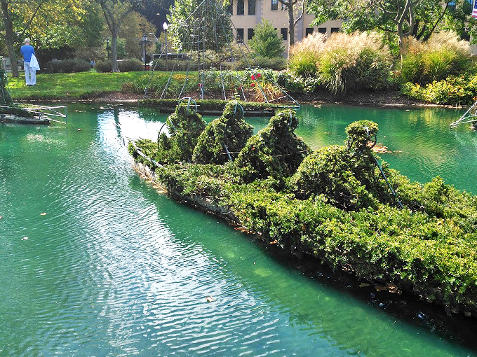 Shrub sculptures come alive! Step into a painting where the brushstrokes are branches and the canvas is a lush, green park.