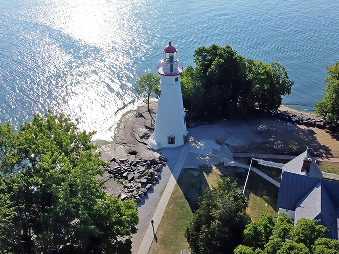 Bird's eye brilliance! The lighthouse gleams like a chess piece on nature's grand board of blue and green.
