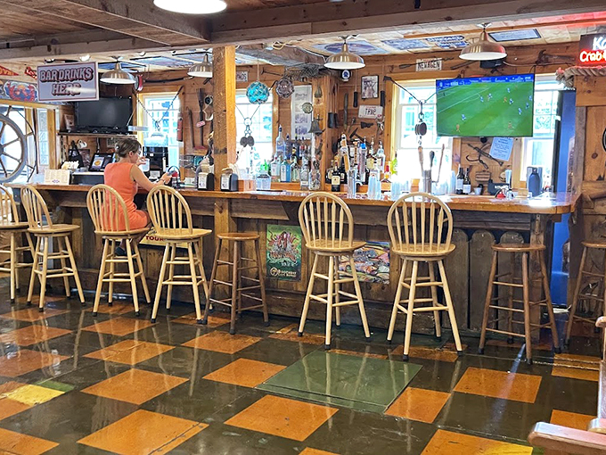 Where nautical charm meets modern comfort - this cozy bar area features checkerboard floors and enough maritime decor to fill a ship's cabin.