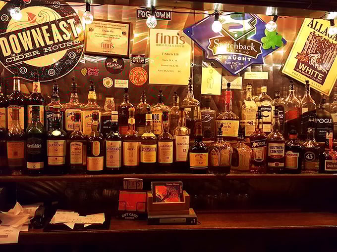 A whiskey lover's dream come true: The bar showcases an impressive collection of spirits beneath vintage-style pub signs and warm lighting.