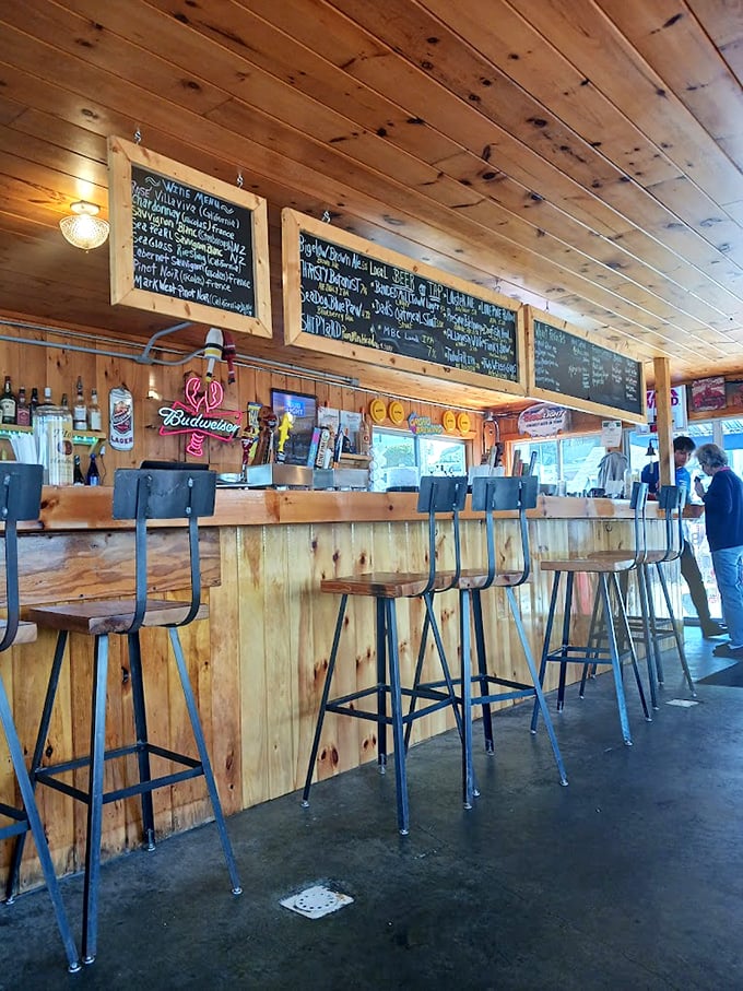 The bar's weathered wood paneling and chalkboard menus tell stories of countless seafood feasts and salty conversations. Photo credit: karen dube