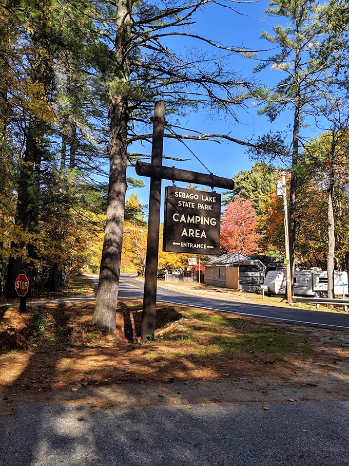 Welcome to paradise! The rustic entrance sign promises adventure ahead, with fall foliage providing a spectacular natural backdrop.