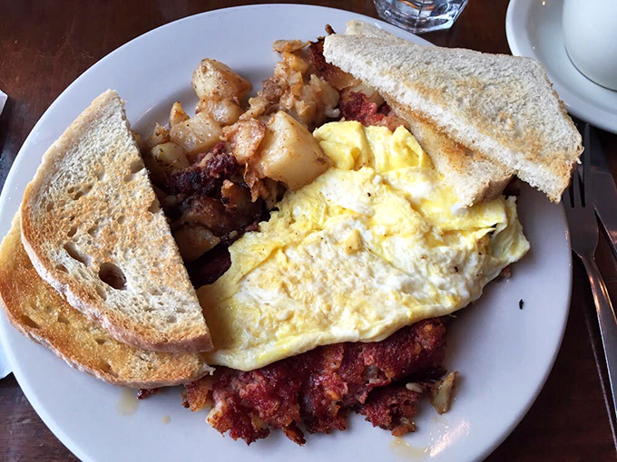 This isn't just breakfast - it's a morning masterpiece of perfectly scrambled eggs alongside that legendary corned beef hash.