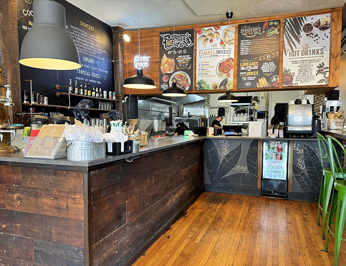 Behind this rustic wooden counter, culinary magic happens daily. The menu board's artistic lettering promises delights that'll make your taste buds dance.