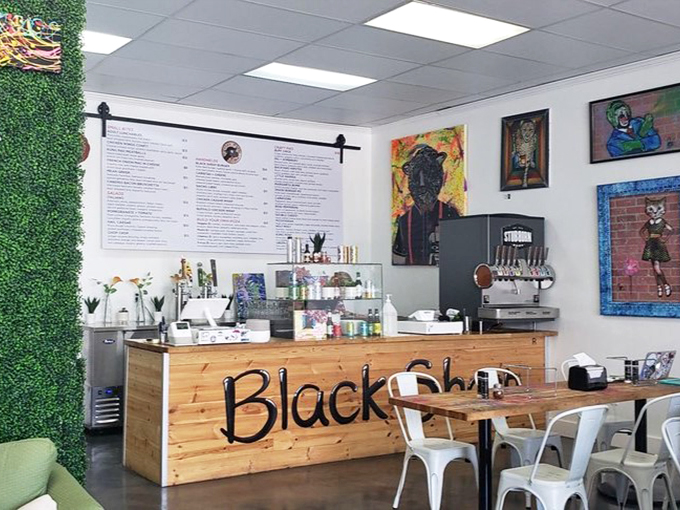 The Black Sheep counter welcomes with rustic wood charm, while the artificial grass wall adds a touch of whimsy to this modern space.