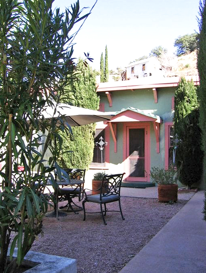 A peaceful courtyard oasis where wrought-iron chairs invite quiet contemplation under the desert sky's endless canvas.