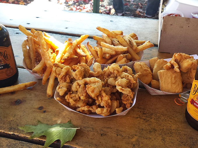 Golden-battered clams and crispy fries share space with Bundaberg sodas, creating a perfect seaside feast on a rustic wooden table.