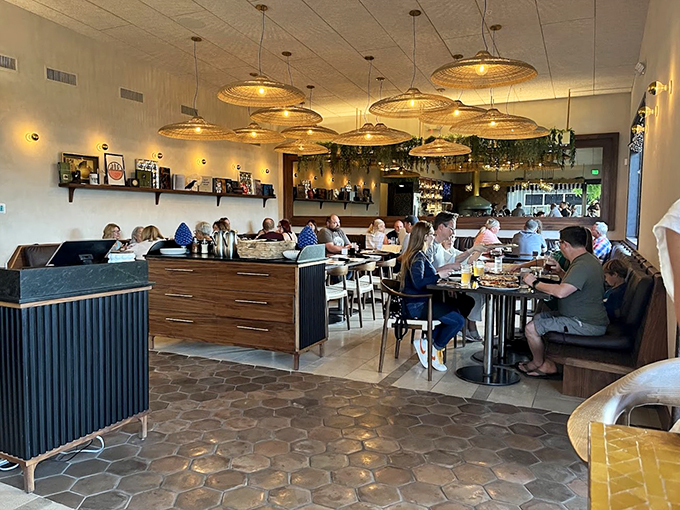 Woven pendant lights cast a warm glow over leather banquettes, while trailing plants create an urban oasis perfect for pizza-powered conversations.