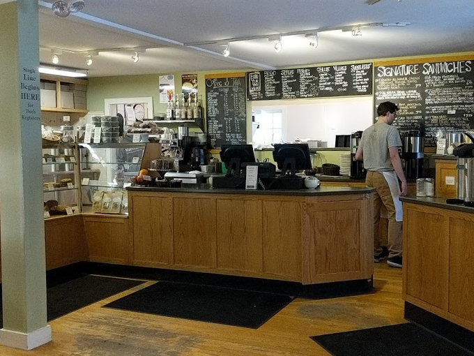 Behind this wooden counter, baking magic happens daily. The chalkboard menu reads like a love letter to artisanal bread. Photo credit: Mingione Beaulieu