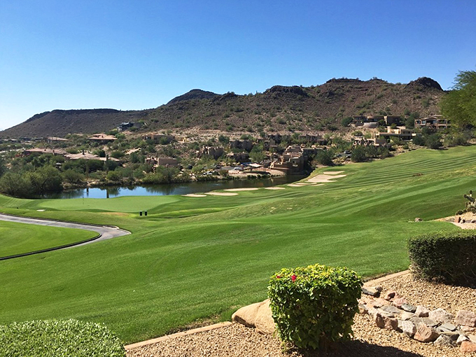 Art meets architecture along the lake's edge, where decorative pillars frame the fountain's majestic display against mountain silhouettes.