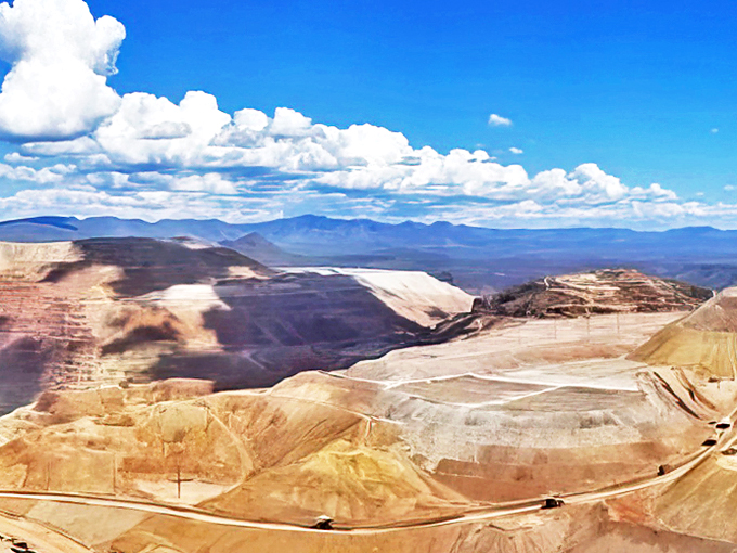 A massive copper mine carves into the earth, creating an otherworldly panorama that looks like Mars decided to vacation in Arizona.