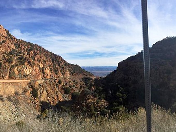 Nestled between towering cliffs, this stretch of road feels like driving through a painting come to life.