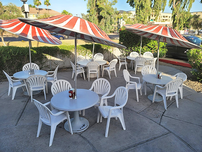 The outdoor patio's red-and-white striped umbrellas offer a shady oasis for enjoying your burger while soaking up that famous Arizona sunshine. Photo credit: joseph kosut