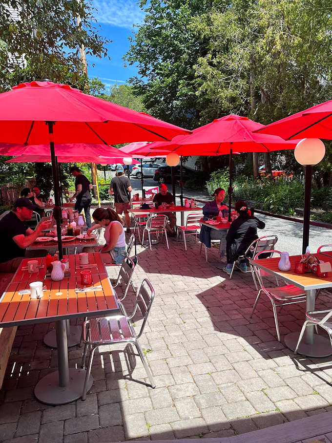Red umbrellas create an inviting oasis on the brick patio. Maine summer dining at its most charming. Photo credit: nancy sowder