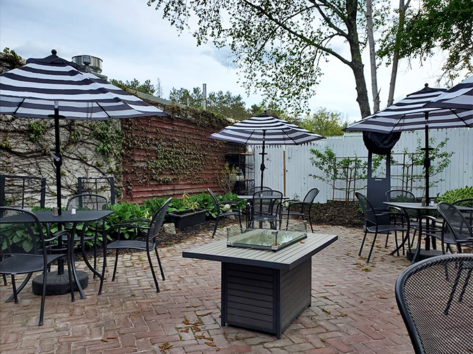 A secret garden patio where striped umbrellas and ivy-covered walls make every meal feel like a summer celebration.