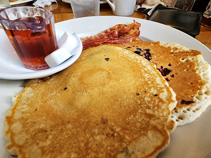 Pancakes so fluffy, they could double as pillows! Paired with bacon that's crispier than a fall leaf, it's a breakfast duet that'll make your taste buds sing.