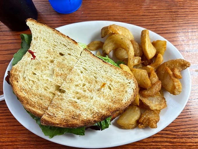 Behold, the sandwich that ate Linwood! This towering testament to gluttony comes with a side of crispy potato wedges and zero regrets.