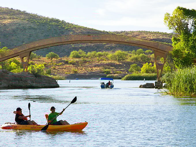 A kayaker's dream unfolds beneath the arched bridge, where desert adventures meet water-based wanderlust.