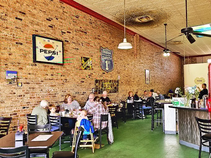 Vintage signs and rustic brick walls tell stories of Bisbee's past, while fresh flowers add a touch of modern charm.