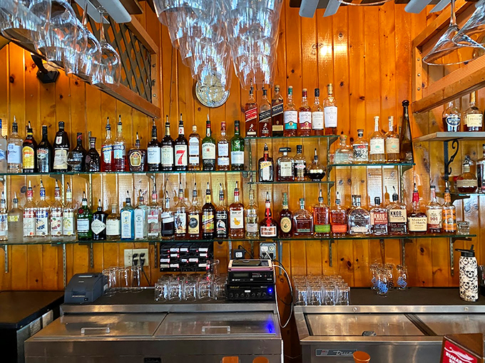 Behind this well-stocked bar, countless stories have been shared over perfectly poured drinks, the knotty pine walls holding decades of memories. Photo credit: Jeff Ferris