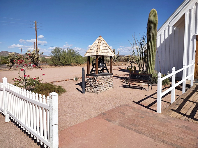 A charming bell tower stands sentinel in the desert sun, its wooden shelter echoing the chapel's rustic Western charm.